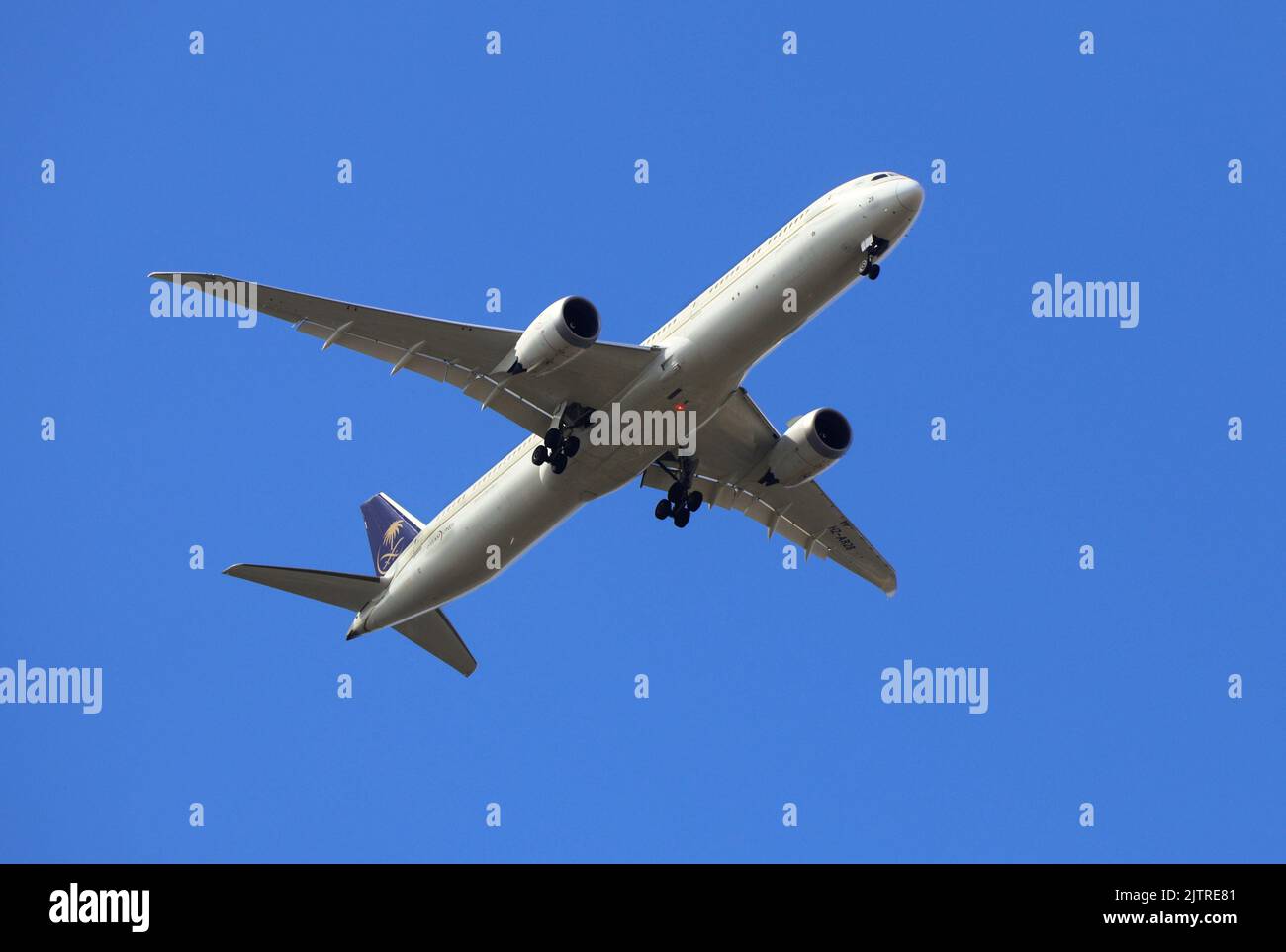 Passenger Jet Aeroplane flying directly above in a bright blue sky ...