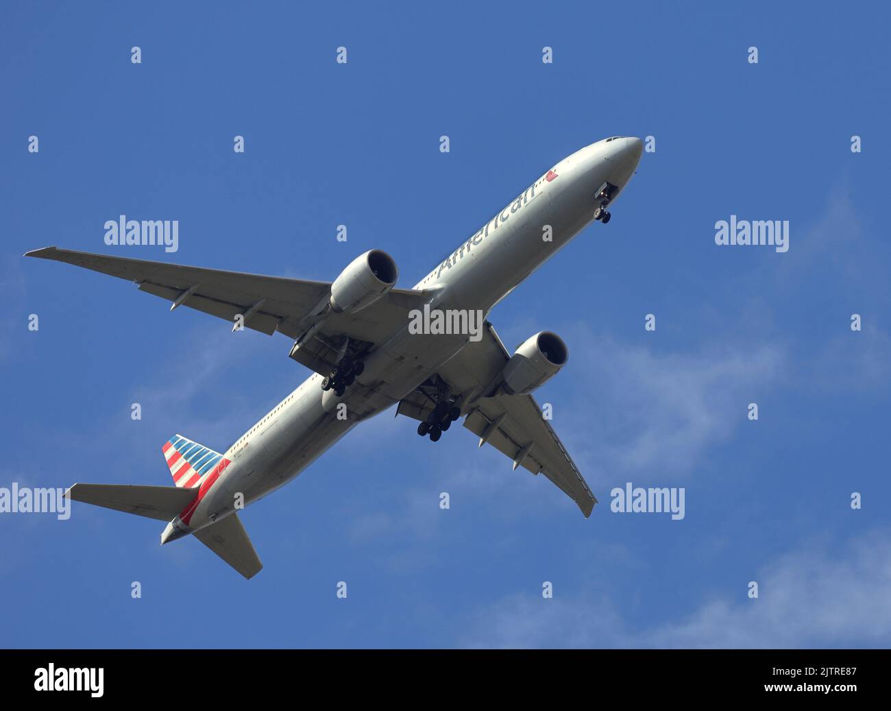 Passenger Jet Aeroplane flying directly above in a bright blue sky ...