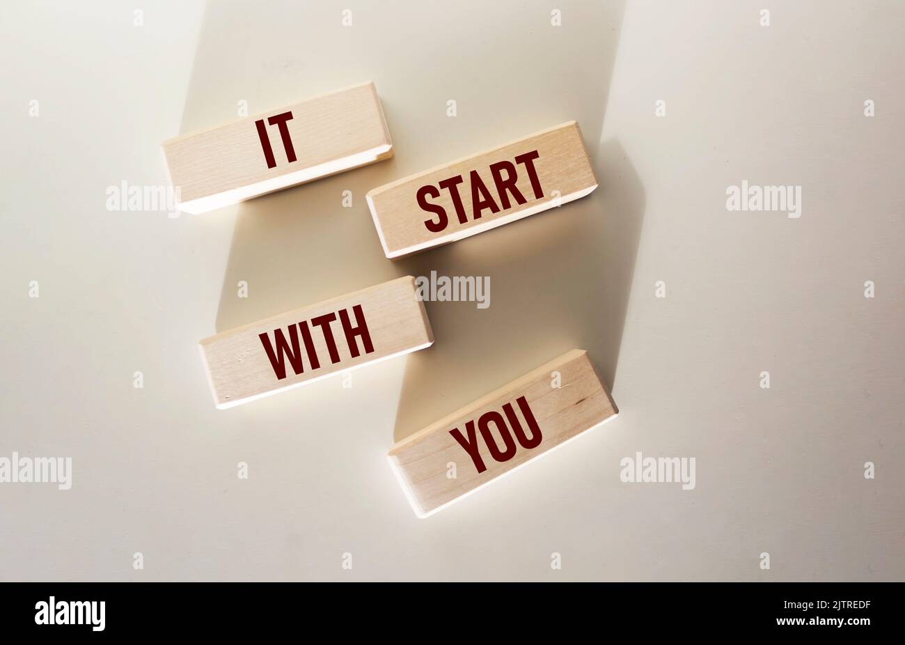 Wooden cubes with the words Everything starts with you. Beautiful light ...