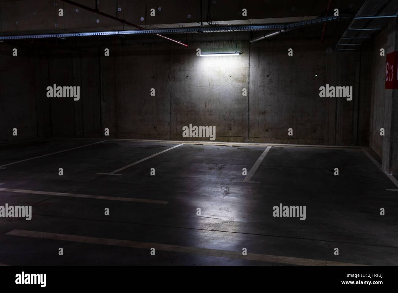 Empty parking lot with overhead dim light, underground parking garage ...