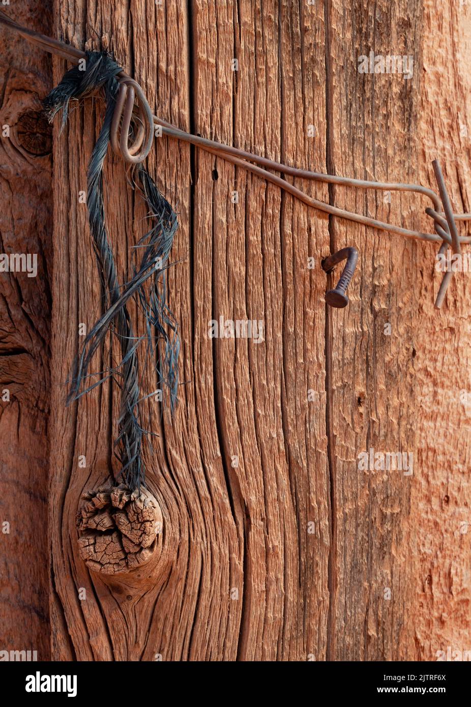 Texture is detailed on a fence post near an old ranch building ...