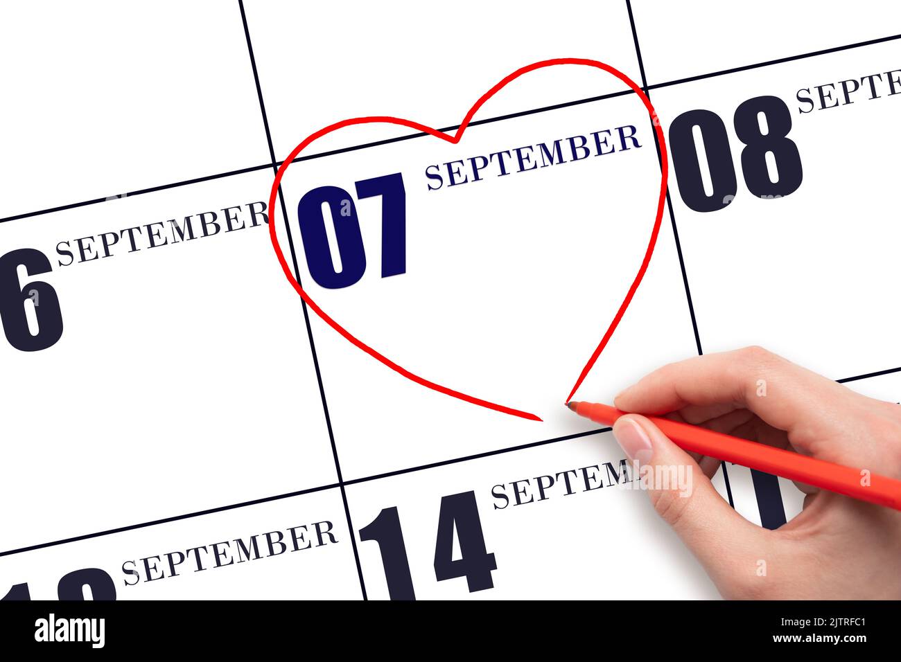 7th day of September. A woman's hand drawing a red heart shape on the ...
