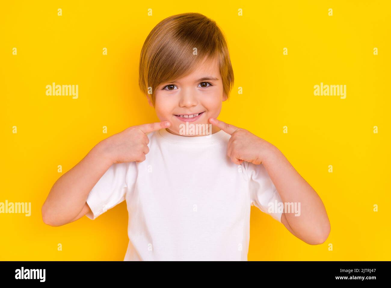 Portrait of handsome cheerful pre-teen boy demonstrating beaming teeth ...