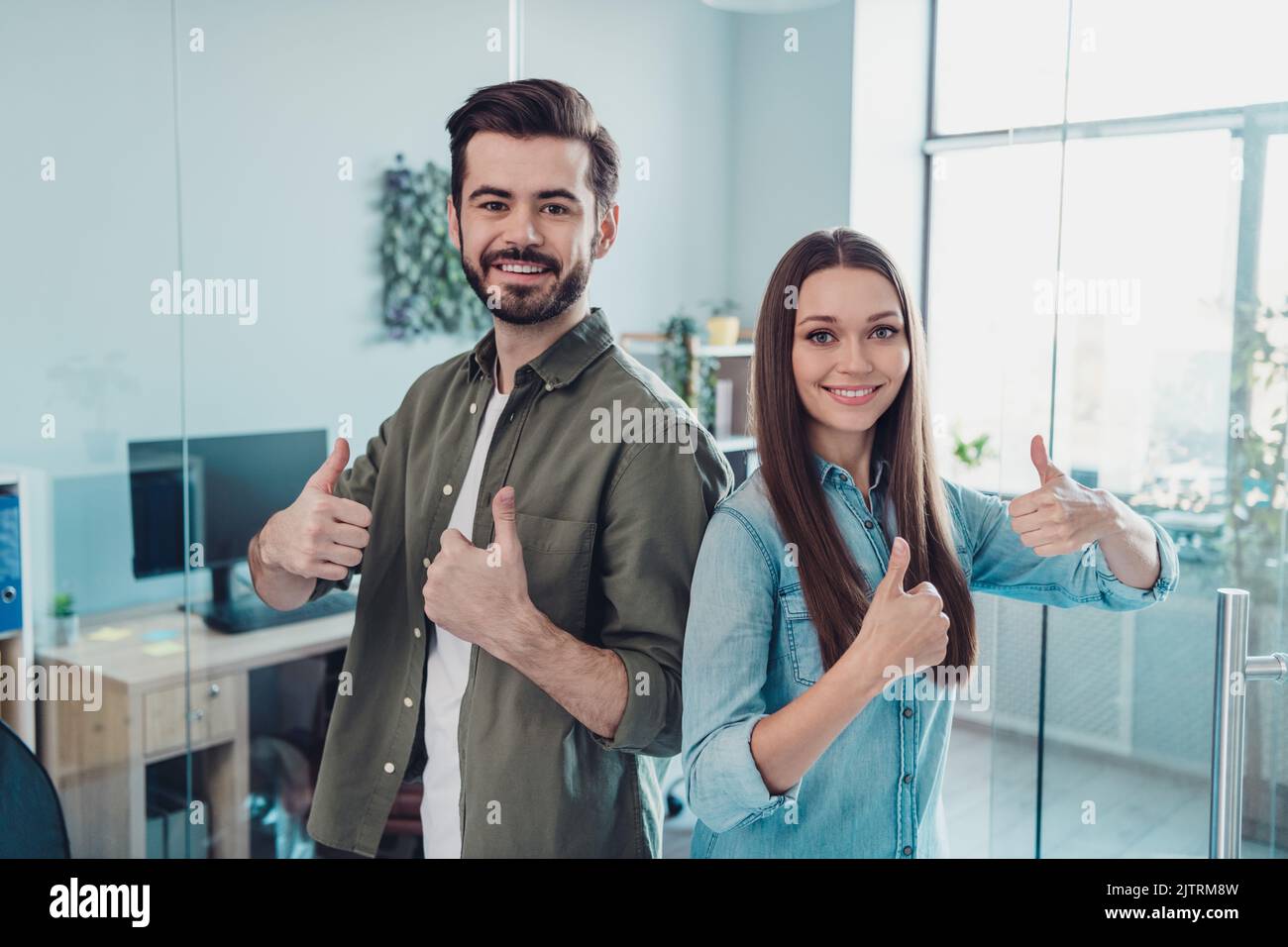 Portrait of two attractive cheerful leaders partners showing thumbup ...