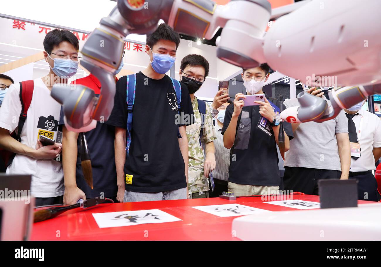 Shanghai. 1st Sep, 2022. Visitors watch an AI robot performing ...