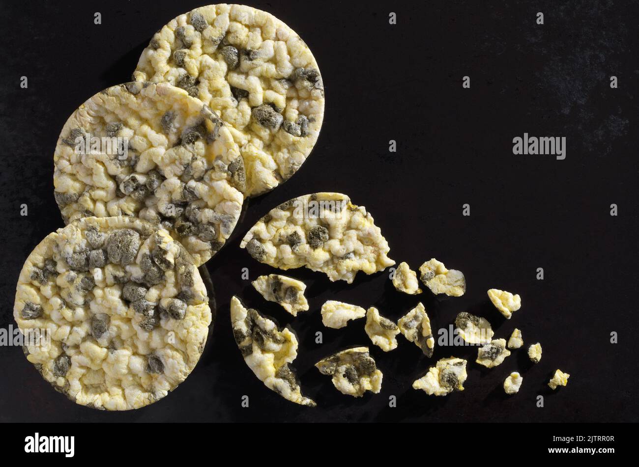 Puffed rice cakes whole and broken on black metal background, top view ...