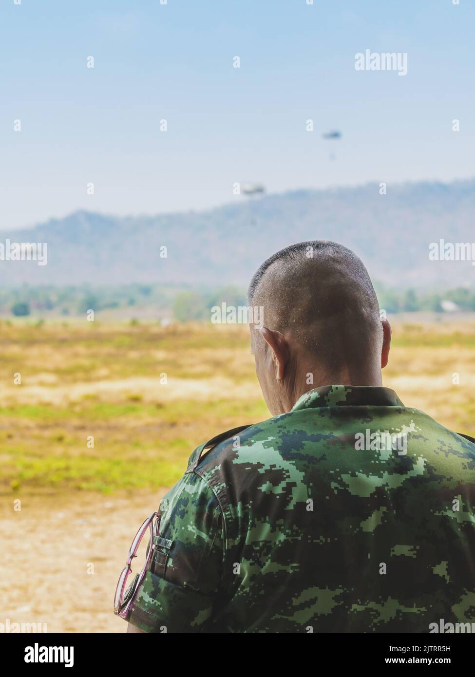Back view of Asian army soldier stands to explore the landscape in ...