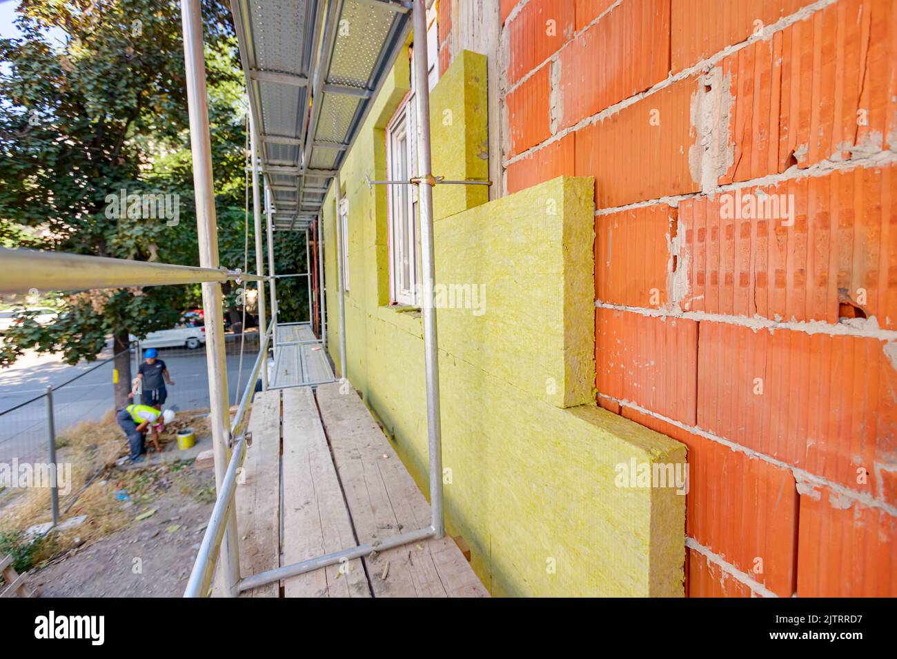 Applying thermal isolation stone wool on the brick wall of residential ...