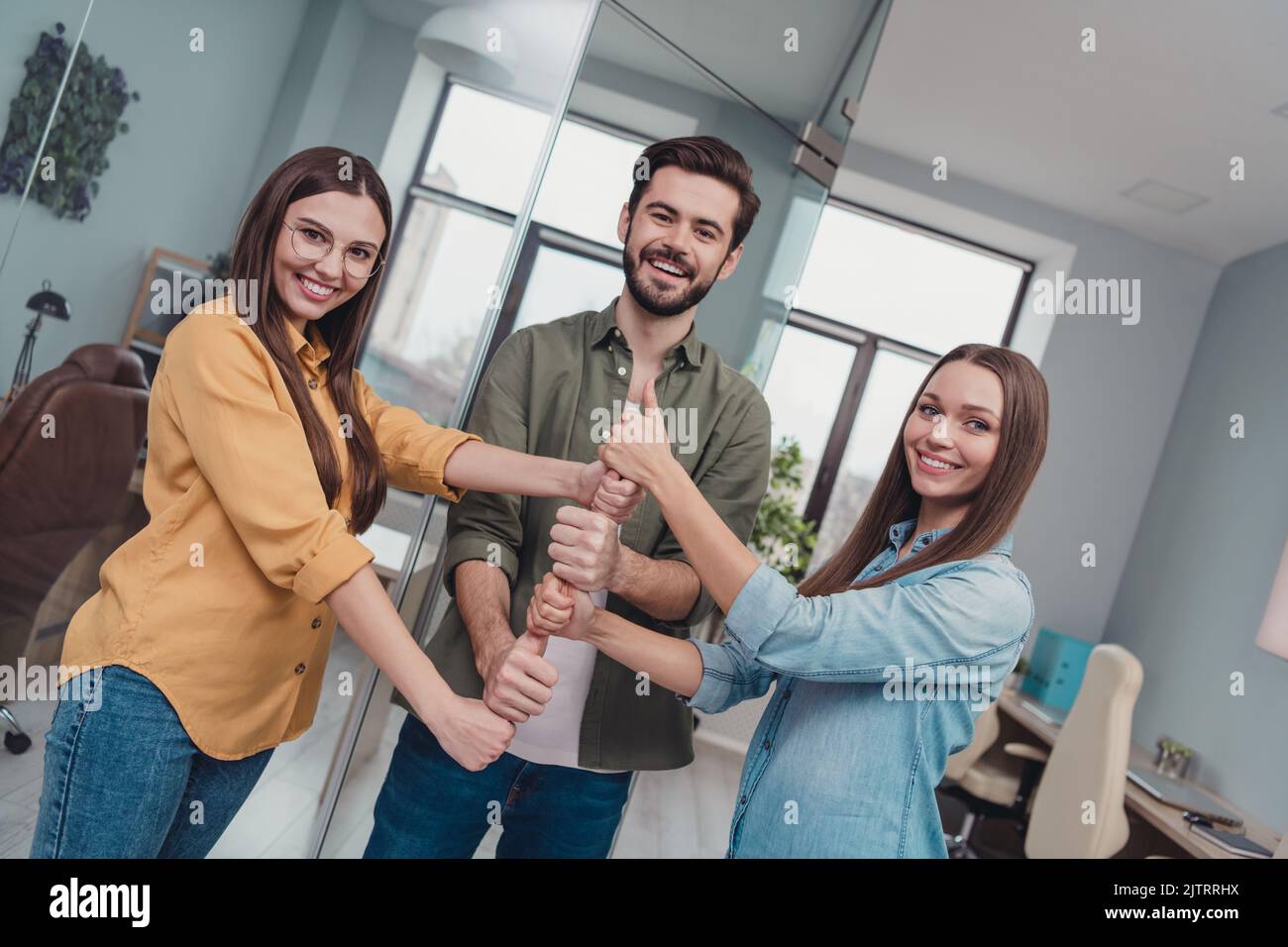 Photo of three cheerful positive student employees cheering up ...