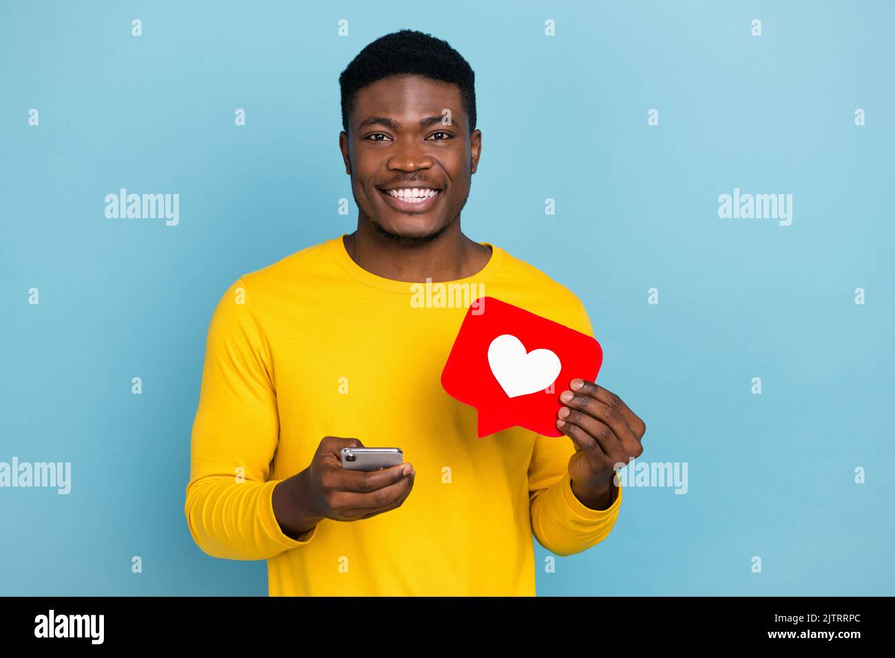 Photo of funny millennial brunet guy hold heart telephone wear yellow ...