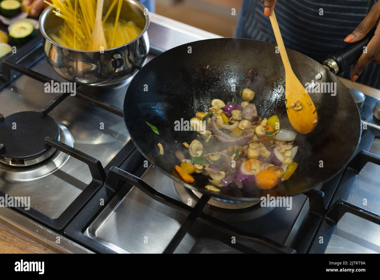 Mid adult woman cooking in kitchen hi-res stock photography and images ...