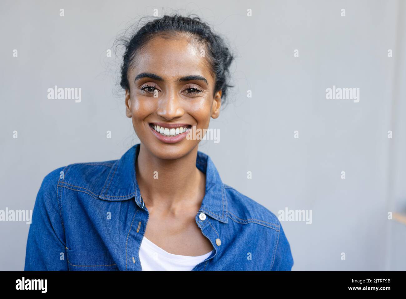 Portrait of smiling biracial mid adult woman wearing denim shirt ...