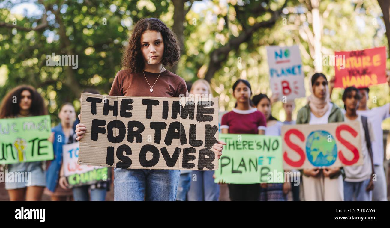 Teenage girl looking at the camera while leading a march against ...