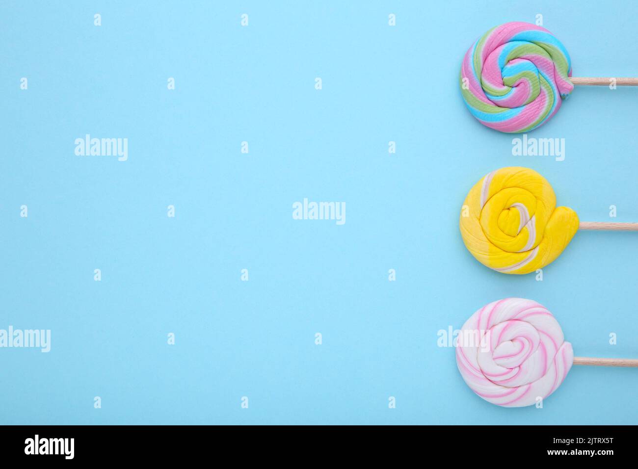Colorful lollipops on blue background. Studio shot Stock Photo - Alamy