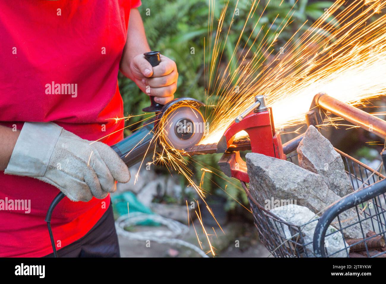 Locksmith man using saw to cut a piece of iron Stock Photo - Alamy