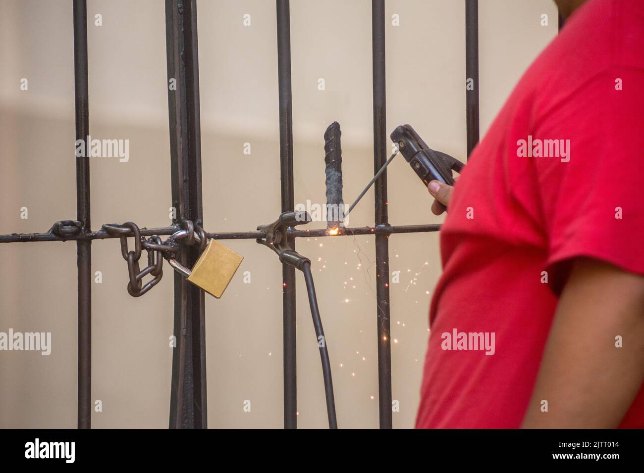 man using welding a piece of iron in an outdoor gate in Rio de Janeiro ...