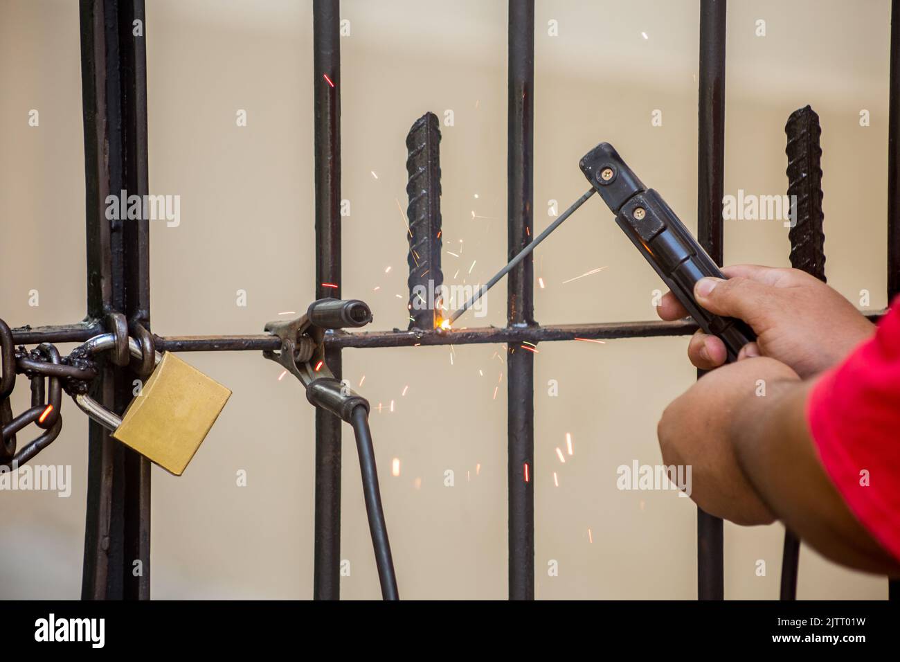 man using welding a piece of iron in an outdoor gate in Rio de Janeiro ...