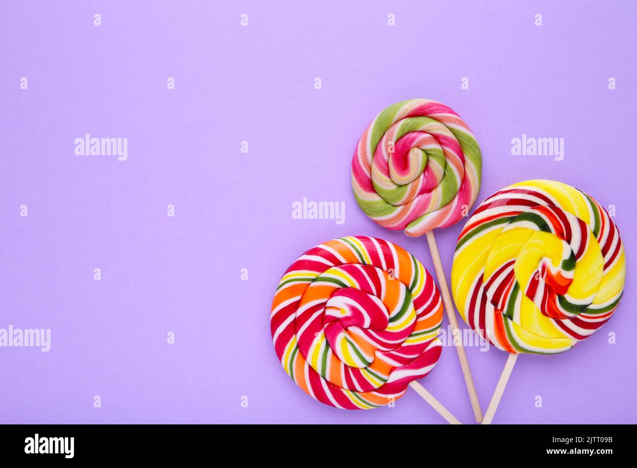 Colorful lollipops on purple background. Studio shot Stock Photo - Alamy