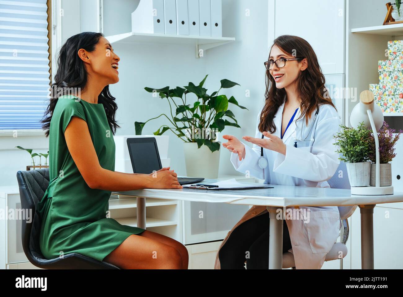 Female doctor smiling explaining treatment to happy woman patient ...
