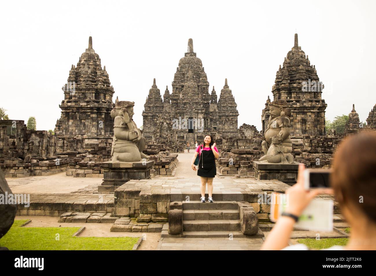 A tourist poses for a photo at the ancient Prambanan Hindu Temple in ...