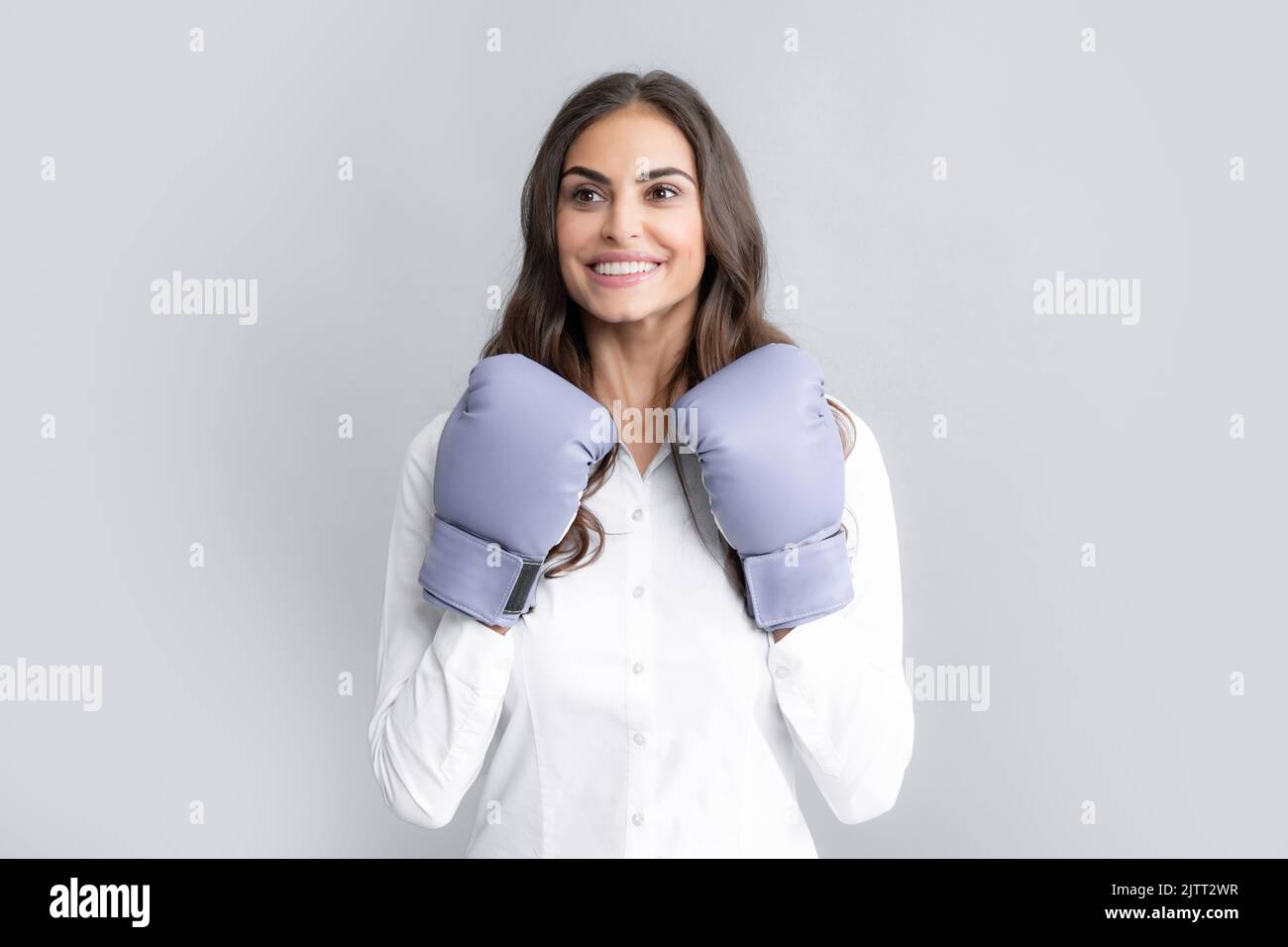 Business woman wearing boxing gloves ready to fight. Strength, power or ...