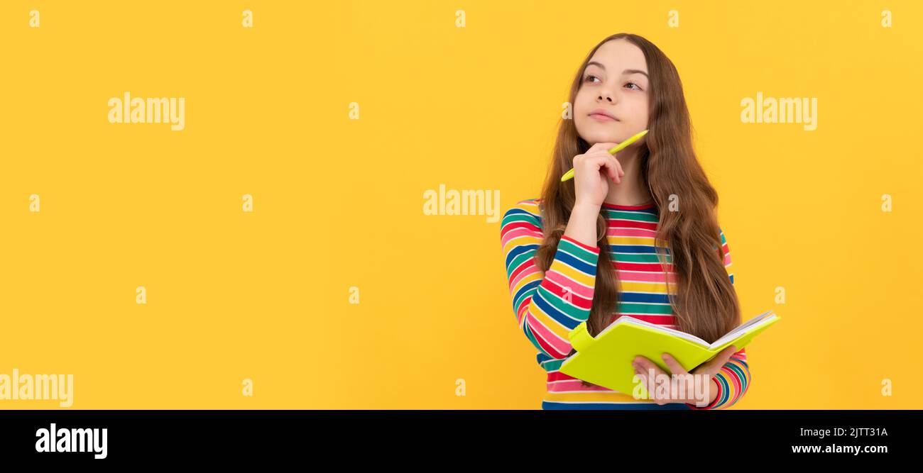 Thoughtful girl child think holding school copybook and pen yellow ...