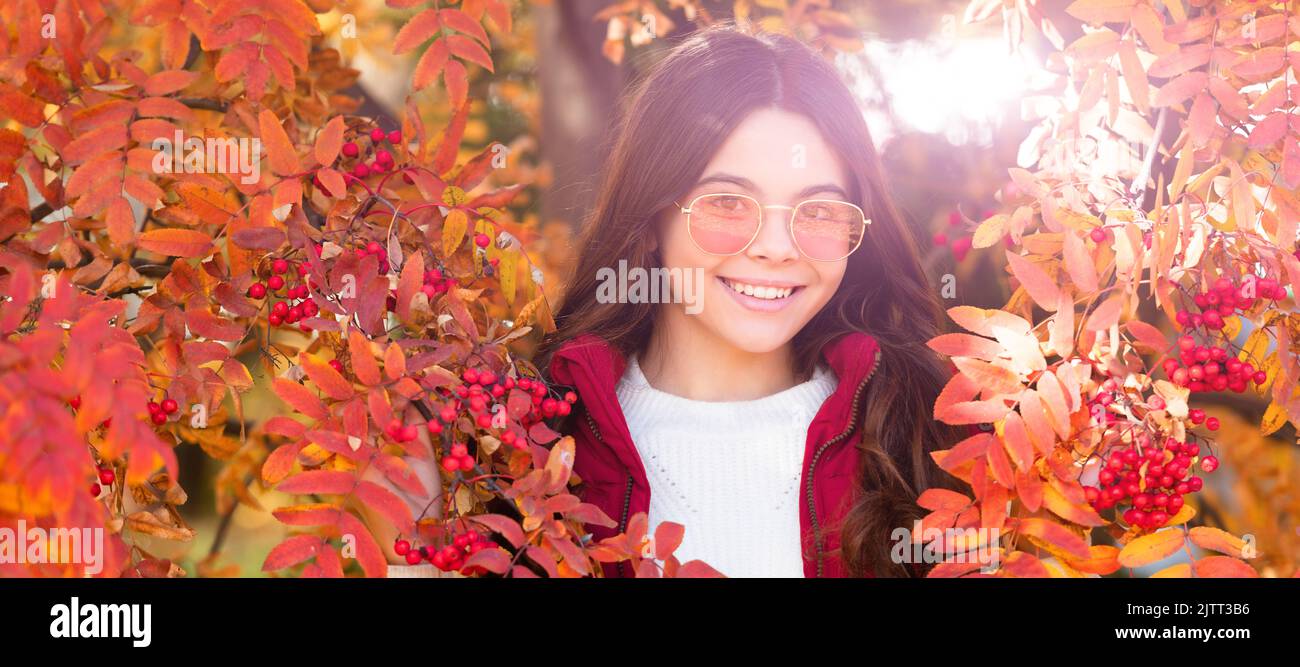 fall season fashion. teen girl with curly hair among autumn rowan ...