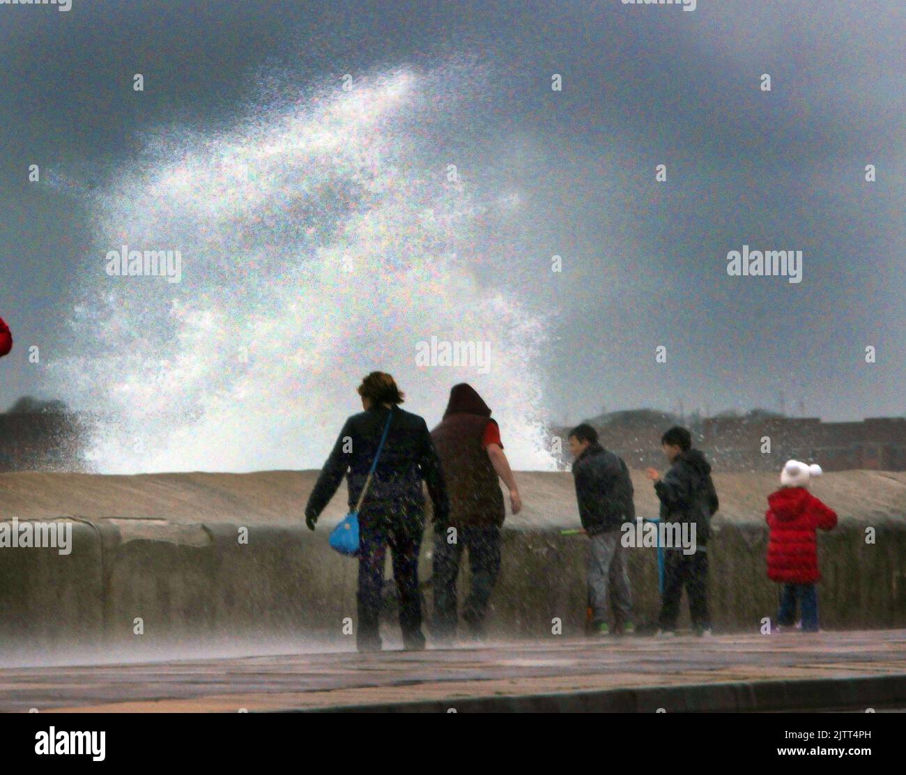 A FAMILY ENJOY A BRACING WALK ALONG THE SEAFRONT AT SOUTHSEA DODGING ...