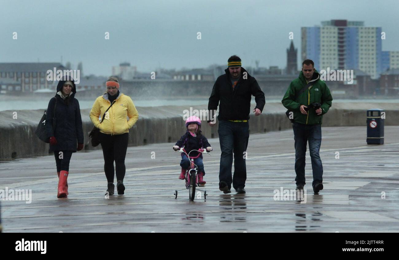 A FAMILY ENJOY A BRACING WALK ALONG THE SEAFRONT AT SOUTHSEA DODGING ...