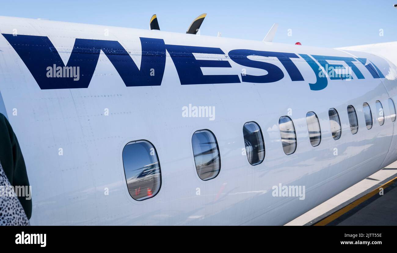 A WestJet planes waits at a gate at Calgary International Airport in ...