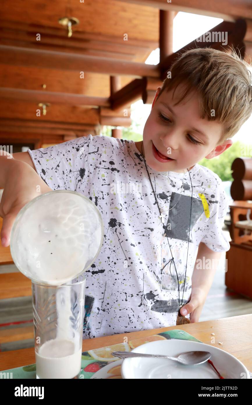 Child pouring melted ice cream in restaurant Stock Photo - Alamy