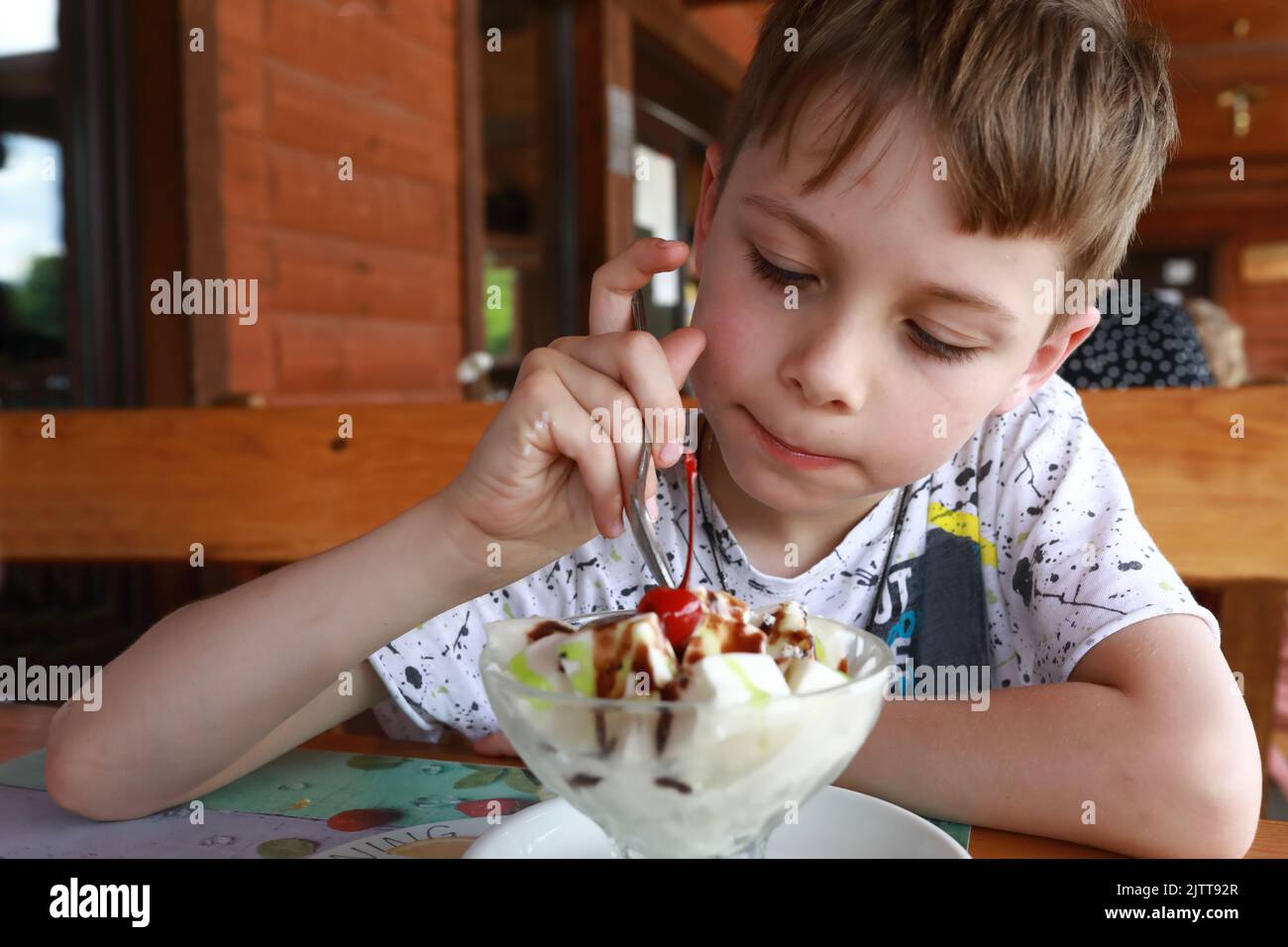 Child eating ice-cream at table in restaurant Stock Photo - Alamy