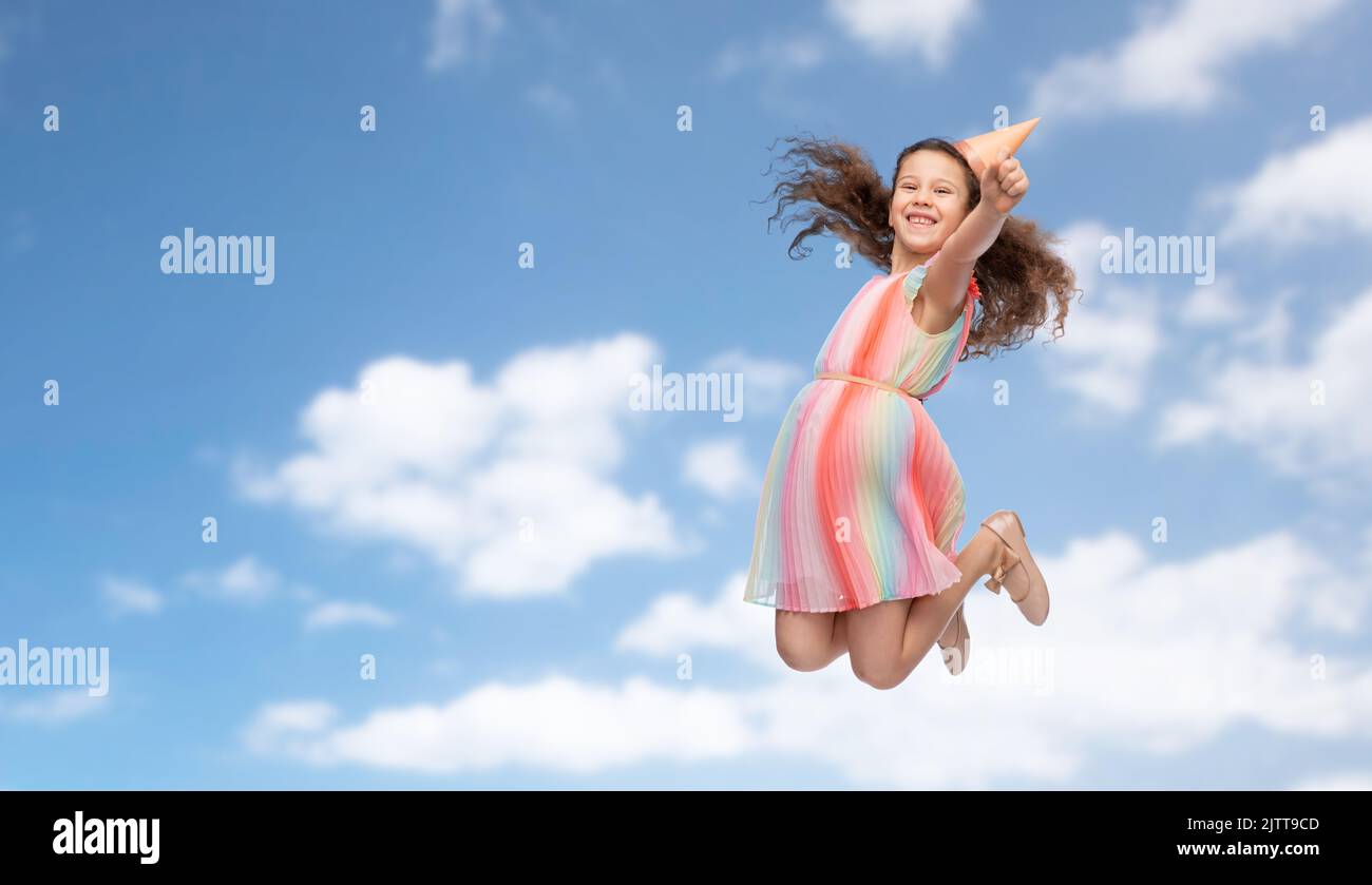 smiling little girl in birthday party hat jumping Stock Photo - Alamy