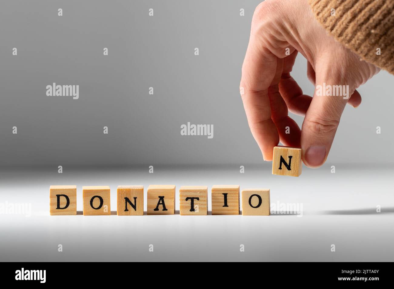 hand making donation word with wooden toy blocks Stock Photo - Alamy