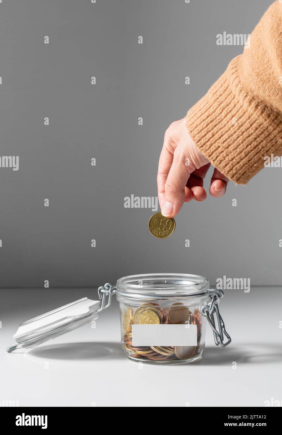 hand putting coin into jar and making donation Stock Photo - Alamy