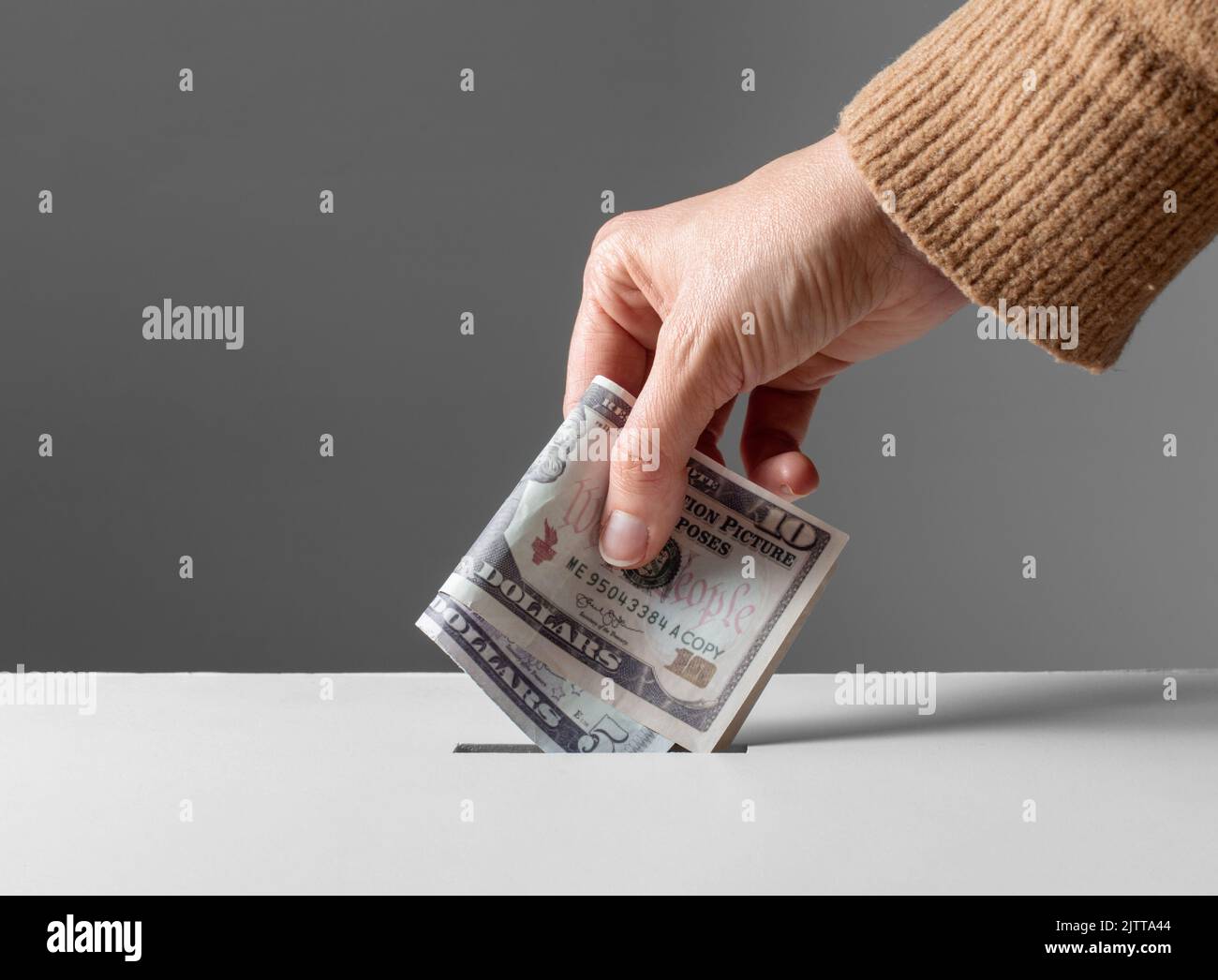 close up of hand putting money into donation box Stock Photo - Alamy