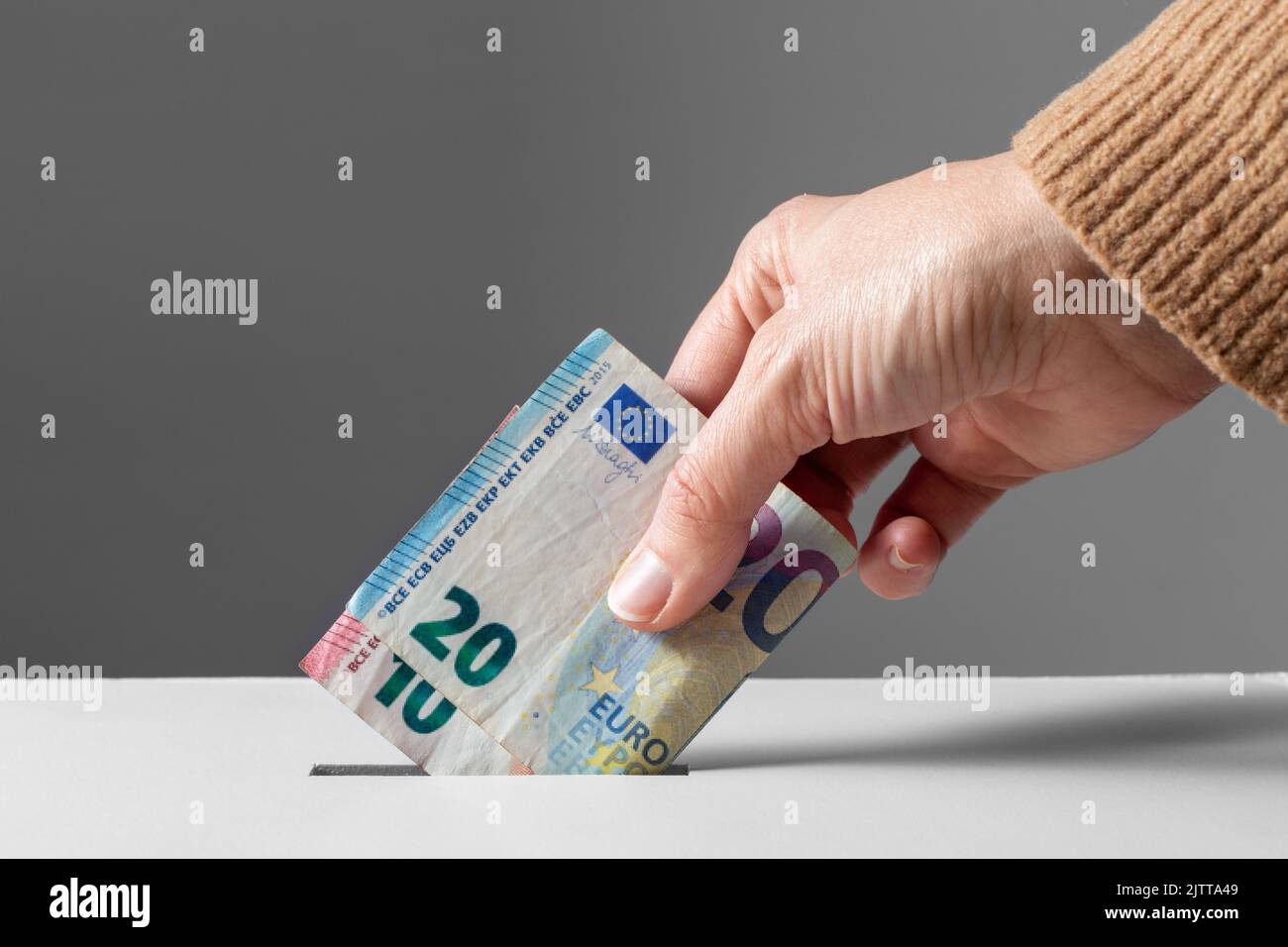 Woman putting money into donation box hi-res stock photography and ...
