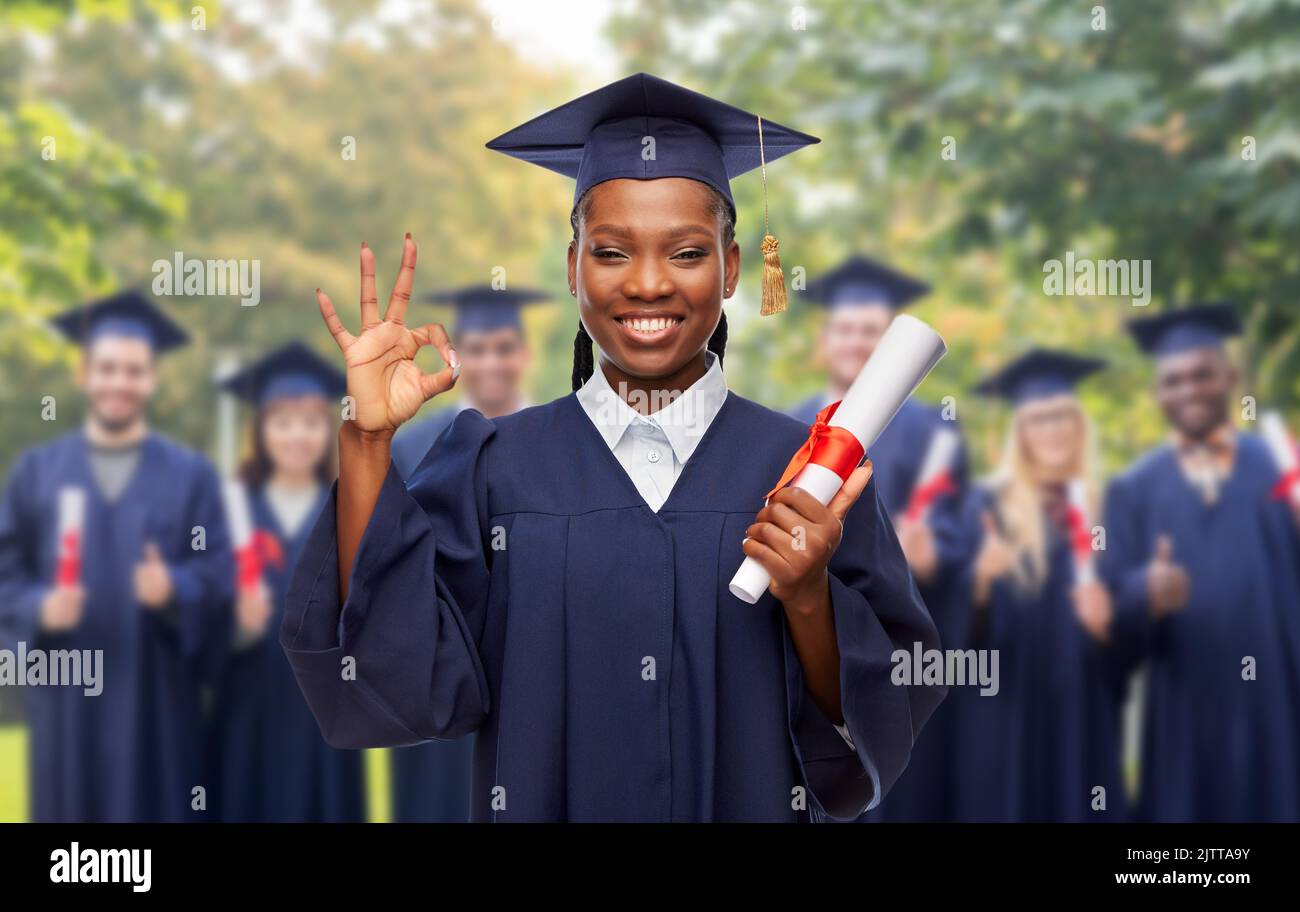 female graduate student with diploma showing ok Stock Photo - Alamy