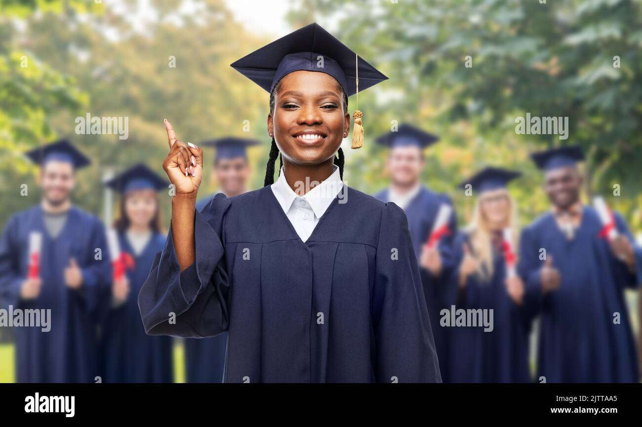 happy female graduate student pointing finger up Stock Photo - Alamy