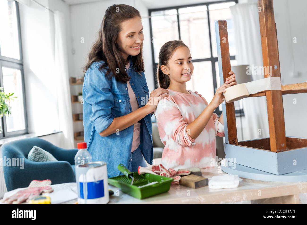 mother and daughter sticking tape to old table Stock Photo - Alamy