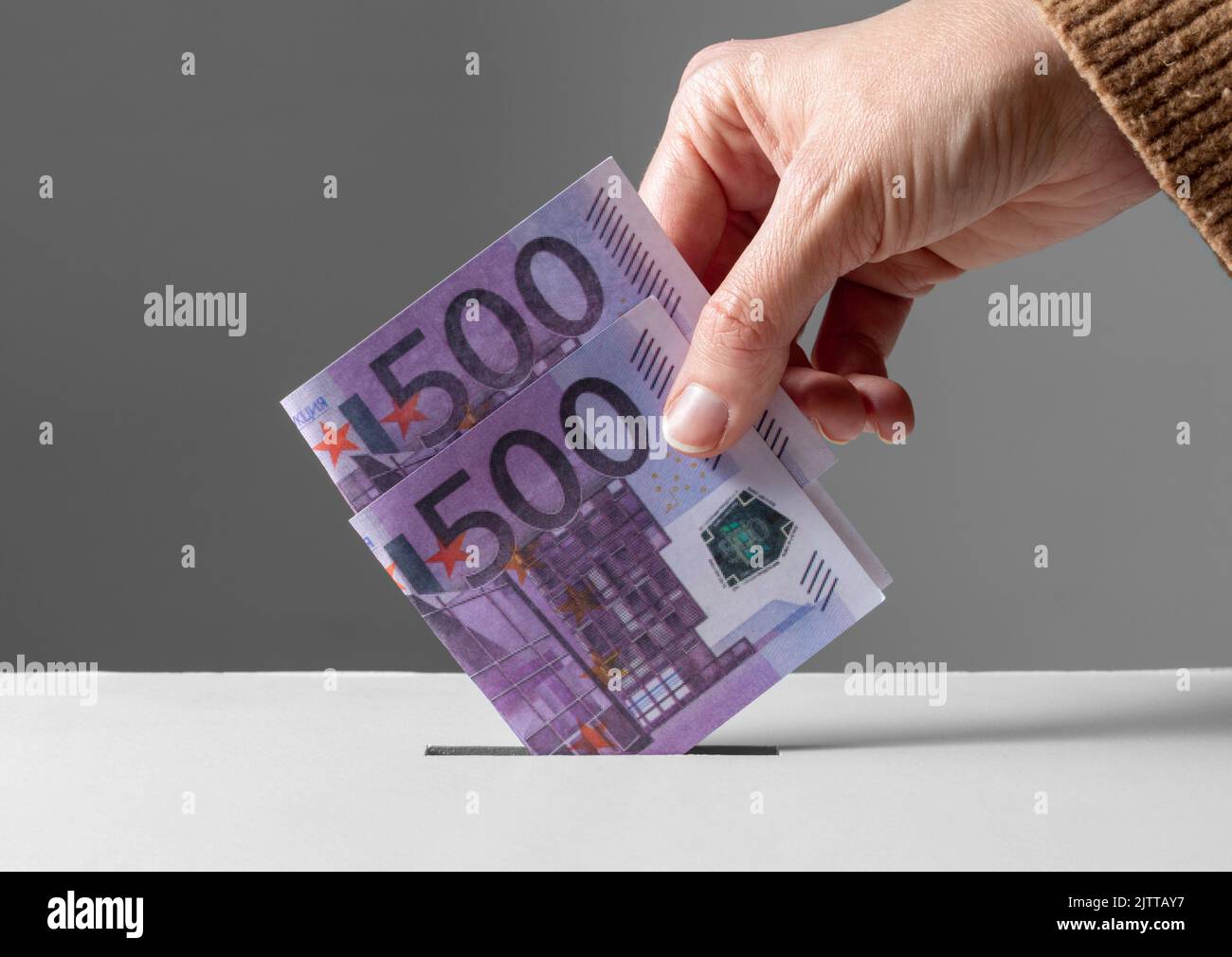 Woman putting money into donation box hi-res stock photography and ...
