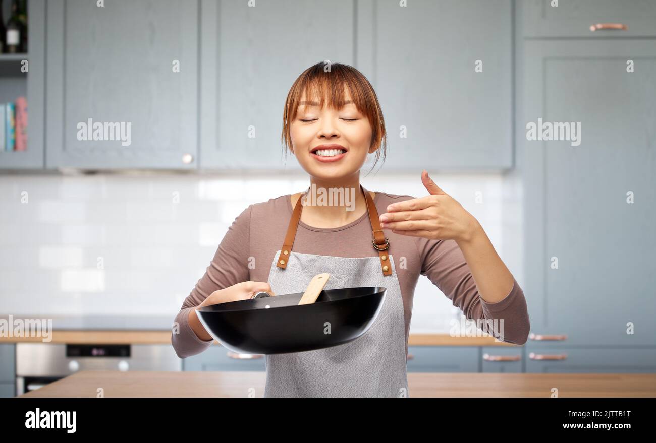happy woman in apron with frying pan smelling food Stock Photo - Alamy