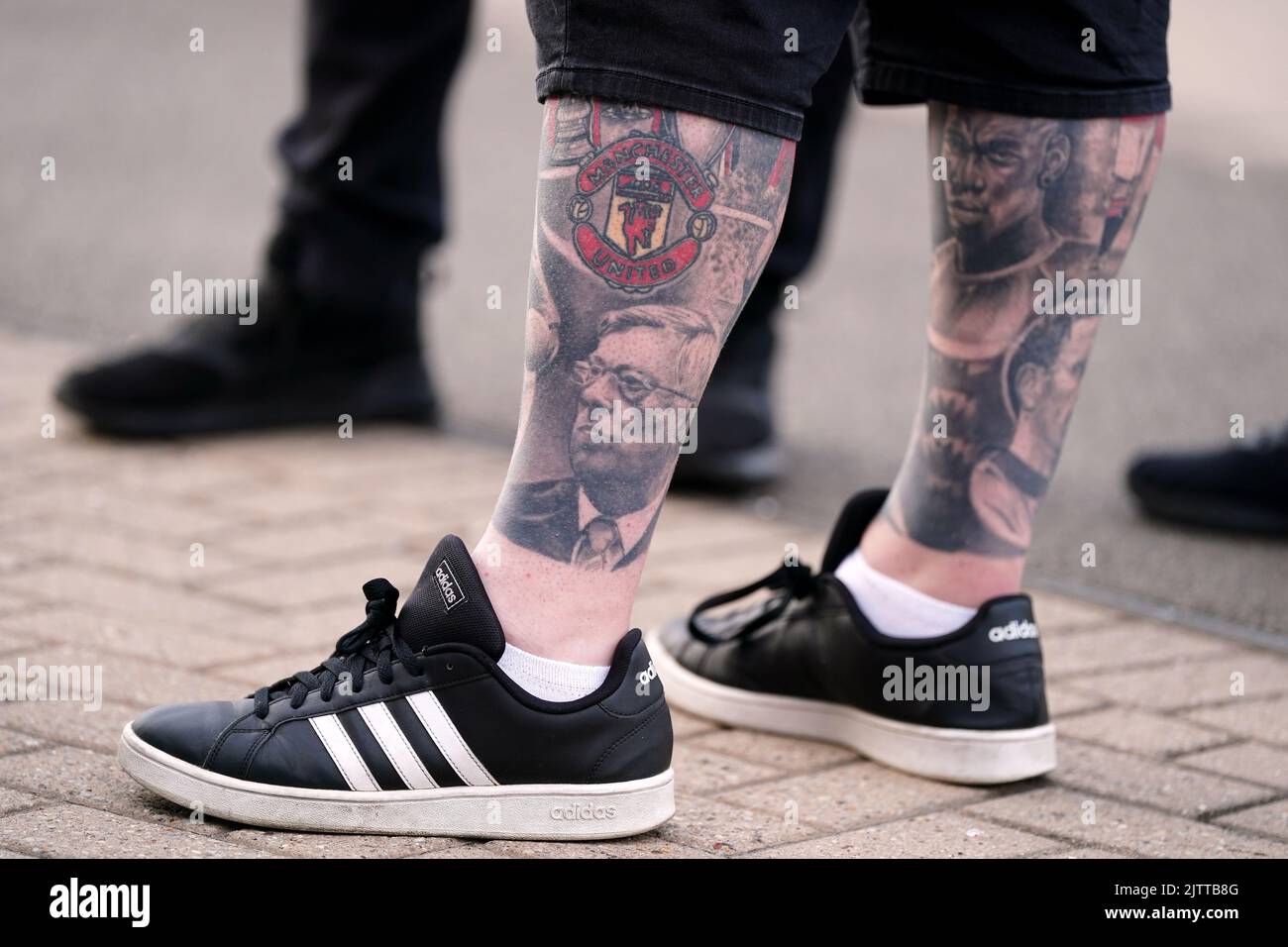 Detail of the tattoos on the legs of a Manchester United fan during the ...
