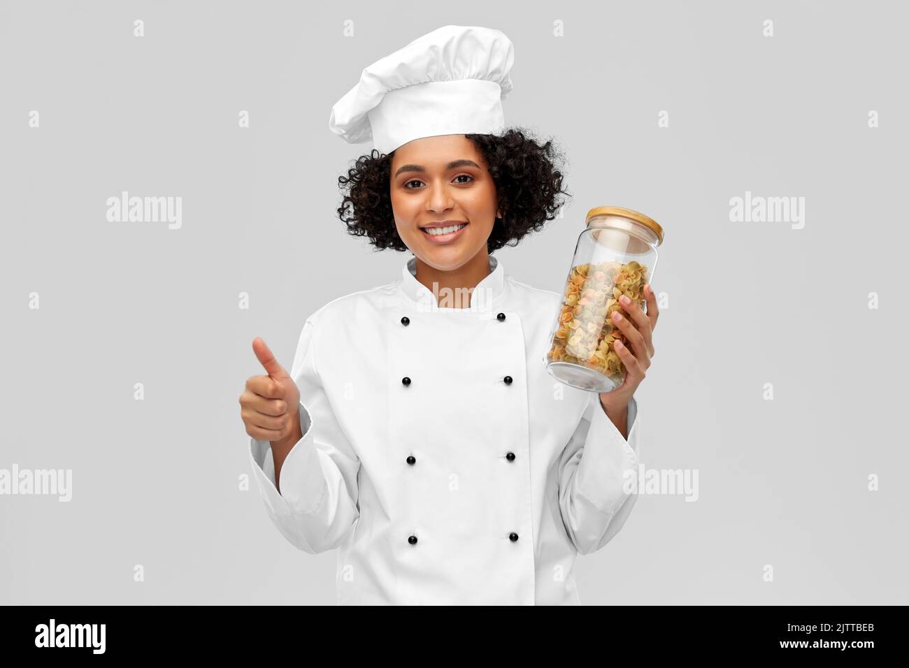 female chef with pasta in jar showing thumbs up Stock Photo - Alamy