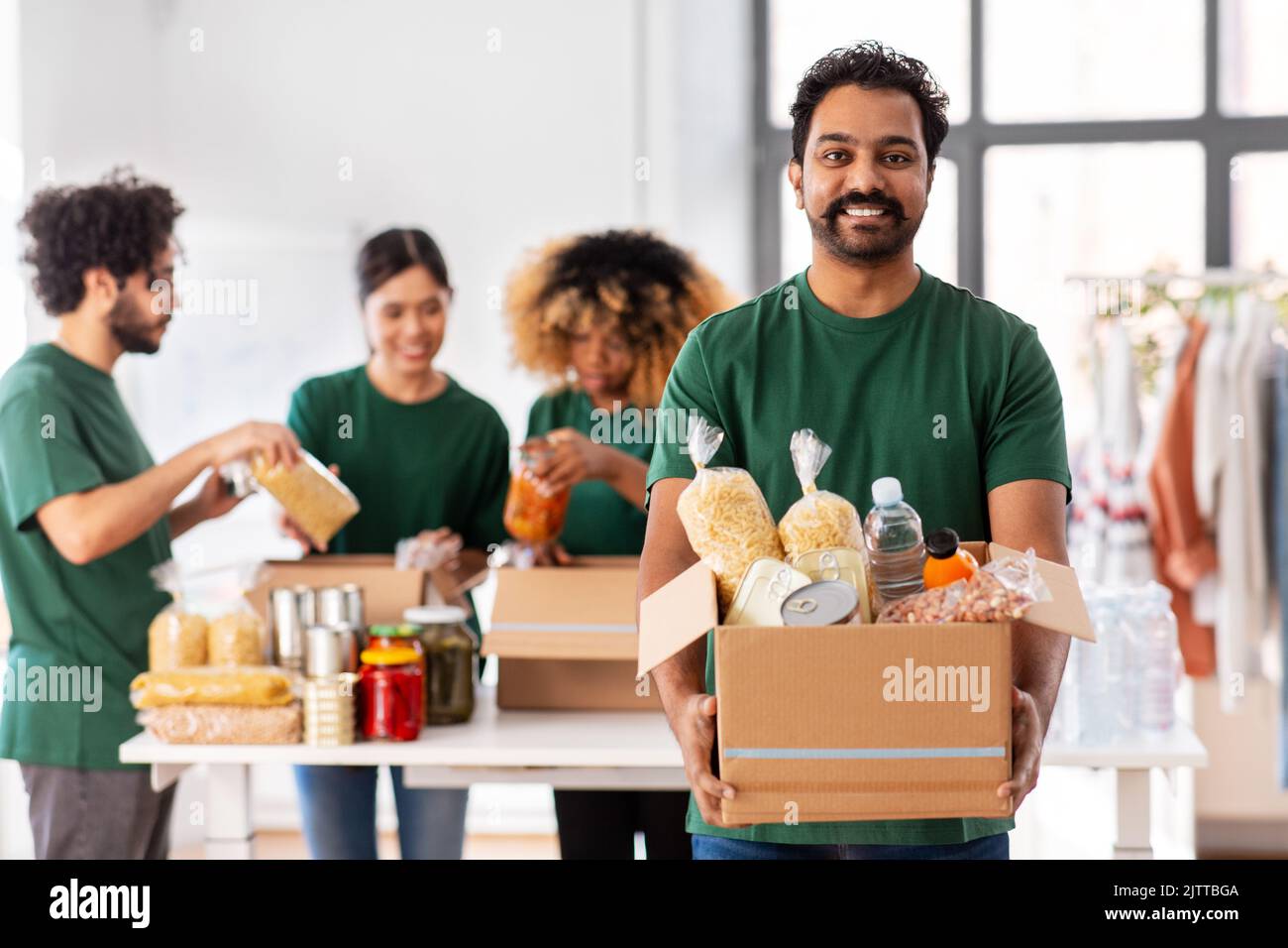 happy volunteers packing food in donation boxes Stock Photo - Alamy