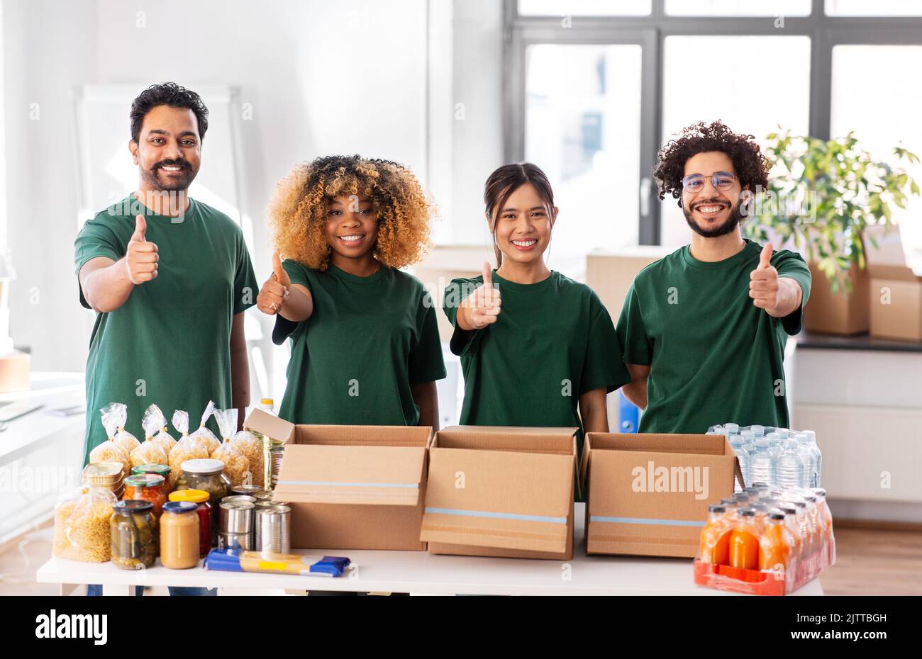 volunteers with food donation showing thumbs up Stock Photo - Alamy