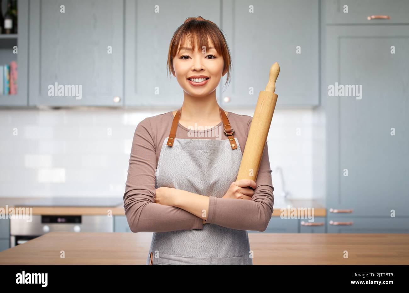 happy woman in apron with wooden rolling pin Stock Photo - Alamy