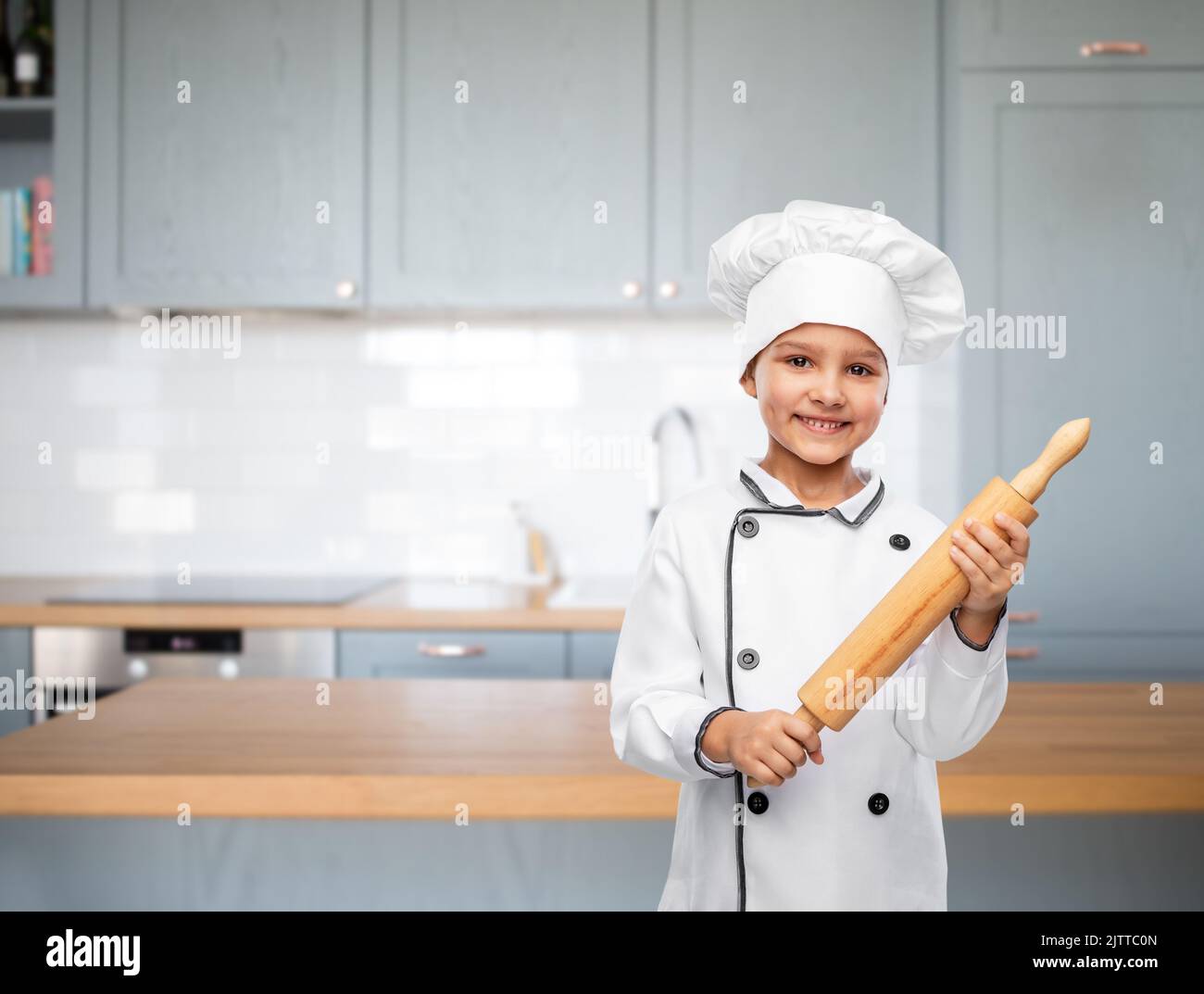 smiling girl in chef's toque with rolling pin Stock Photo - Alamy