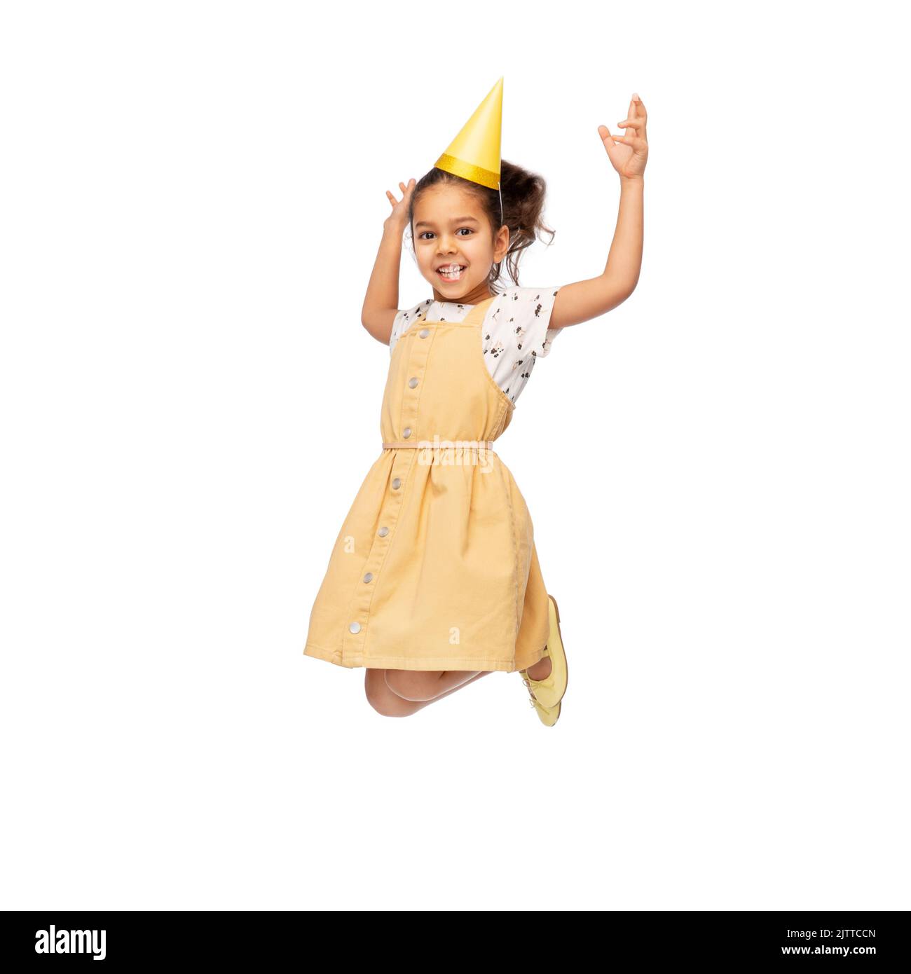 smiling little girl in birthday party hat jumping Stock Photo - Alamy