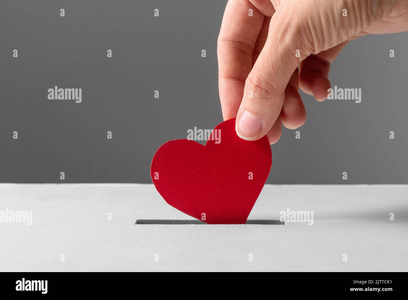 hand putting red heart into donation box Stock Photo - Alamy